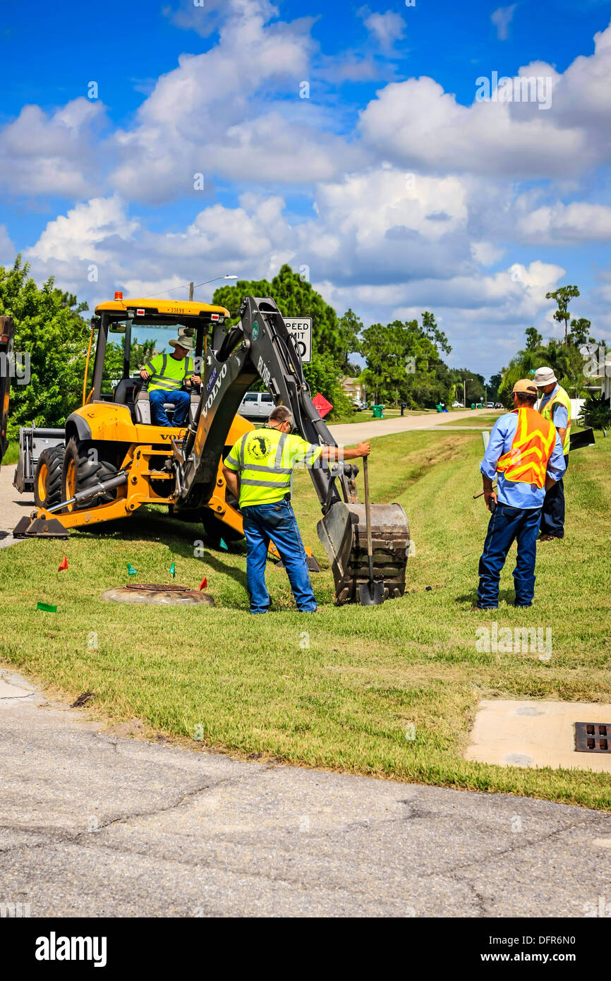 Public Works Dept workers dig out and replace a blocked rain water ...