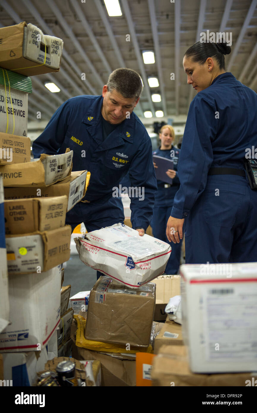 Chief Logistics Specialist Christopher Arnold sorts packages of mail ...