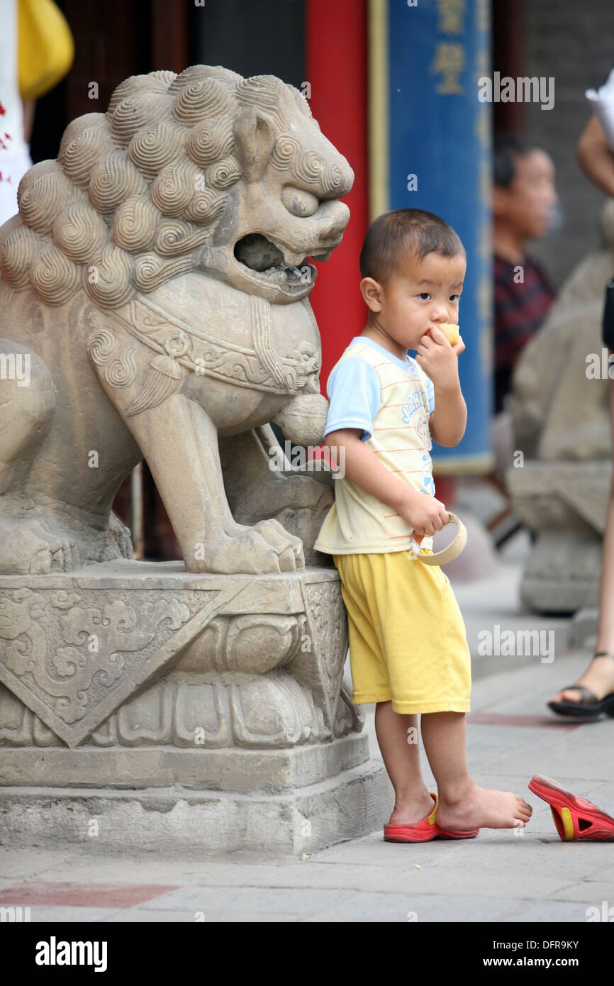 Chinese child eating an apple in the street, Xian, China Stock Photo ...