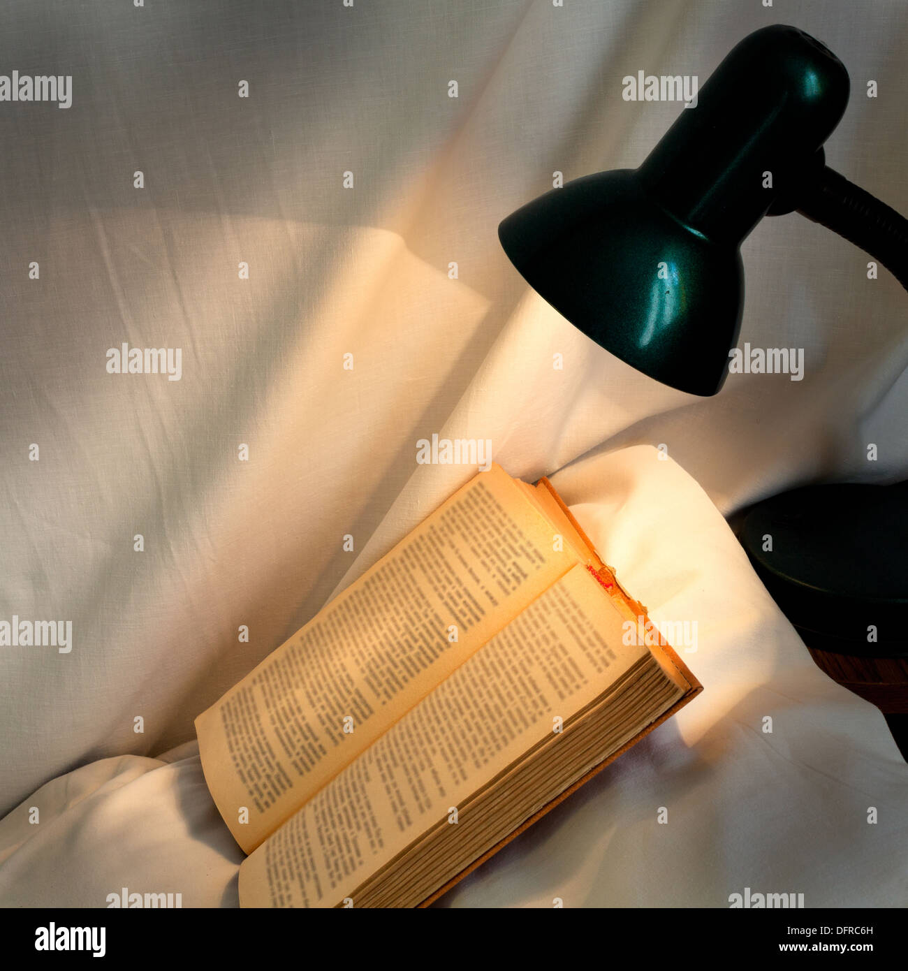 book on pillow lit reading lamp at night Stock Photo - Alamy