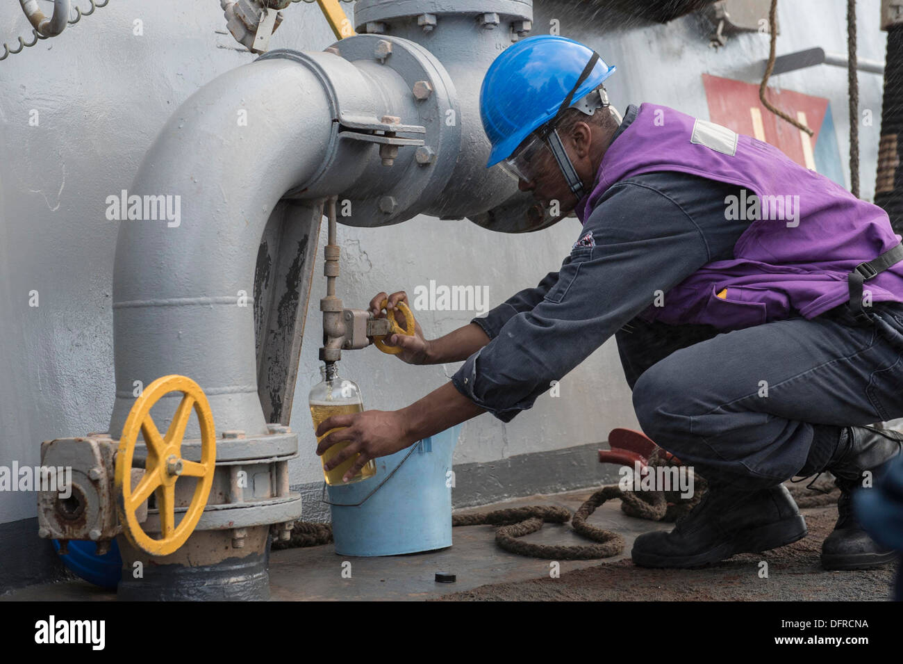 Damage Controlman 2nd Class Craigory Bradford fills a sample bottle for ...