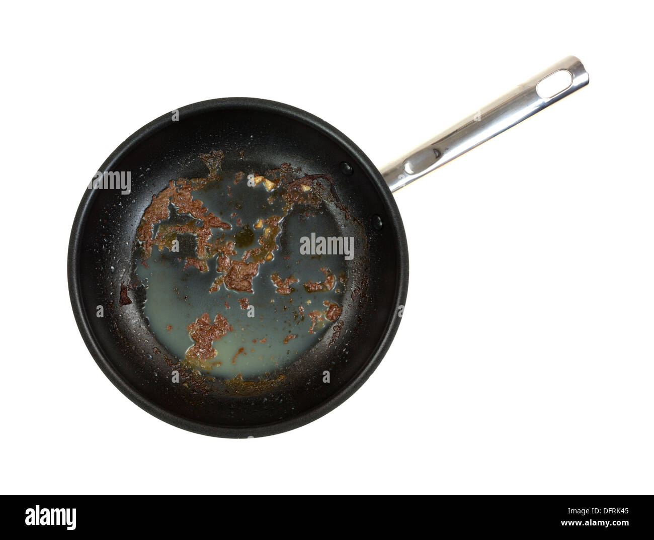 A frying pan with the leftover grease from fried hamburgers on a white ...