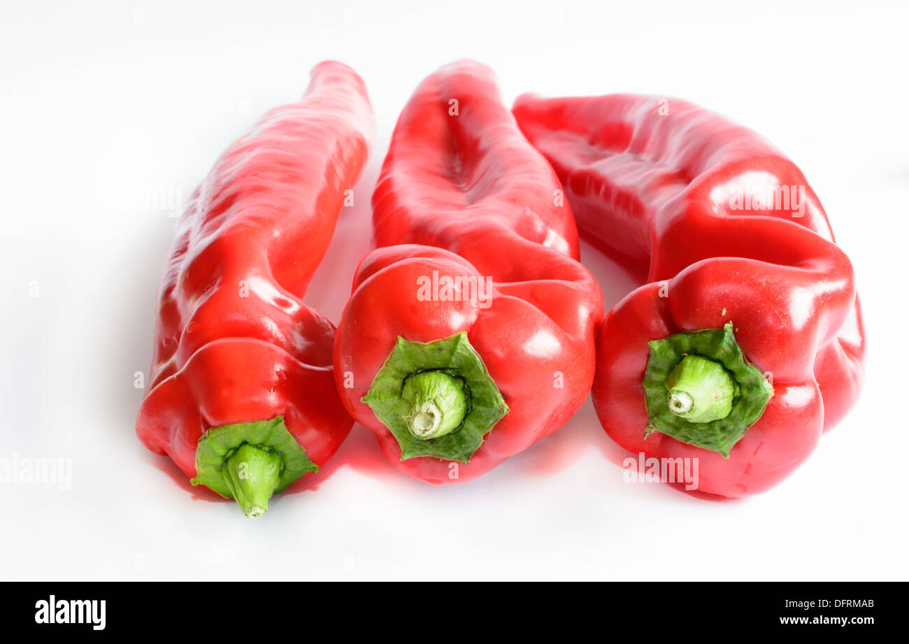 Three red peppers front view on white background Stock Photo - Alamy