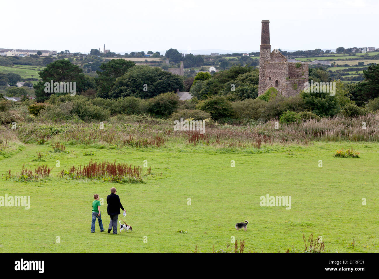 People walking their dog in a landscape of disused mining works, Four ...