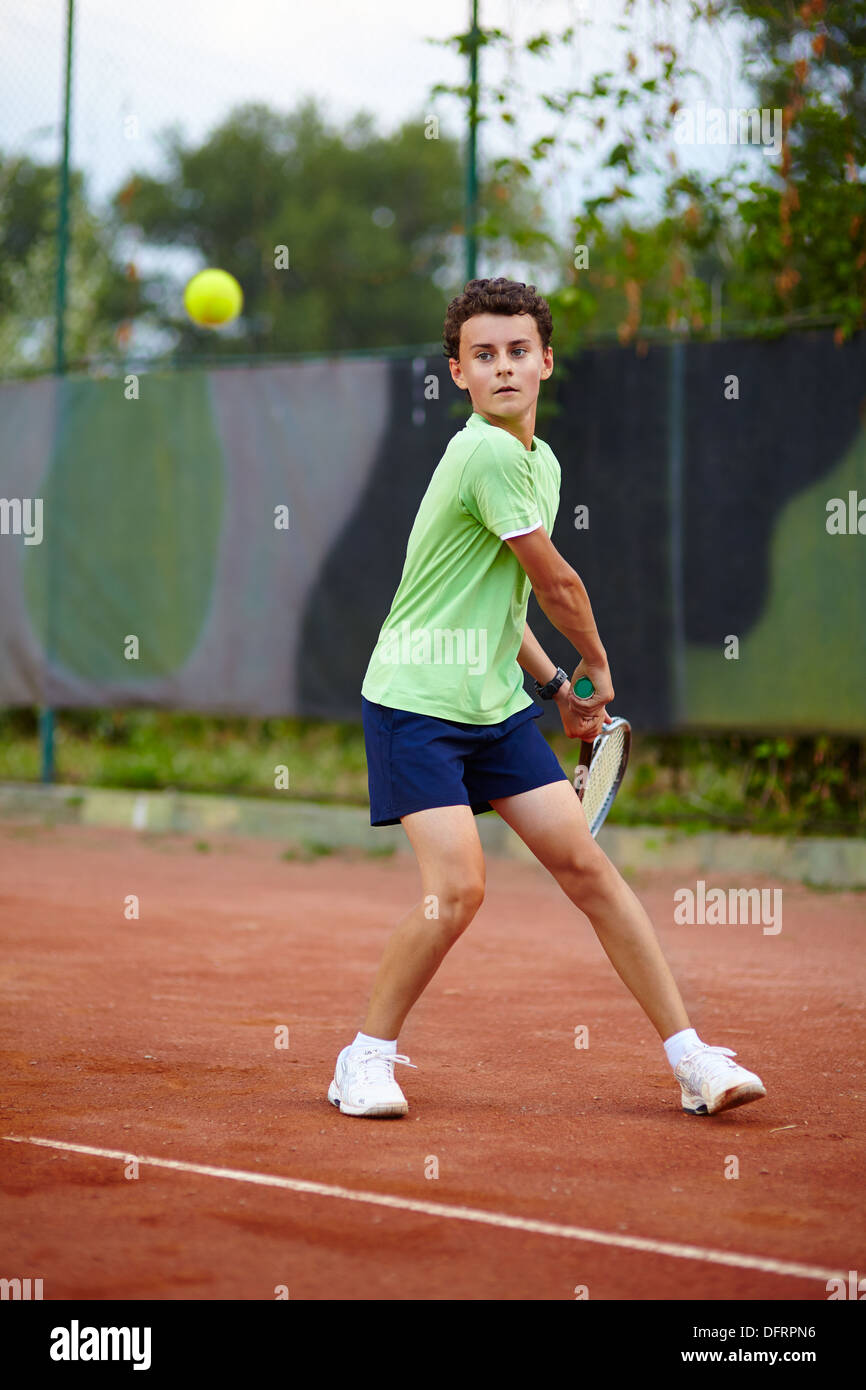 Child hitting the ball with the backhand on a dross court Stock Photo ...
