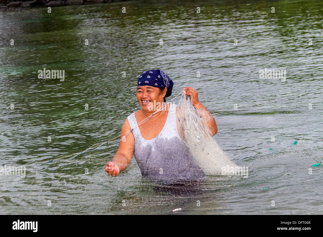 Local woman fishing by net in shallow waters off the beach in Kosrae ...