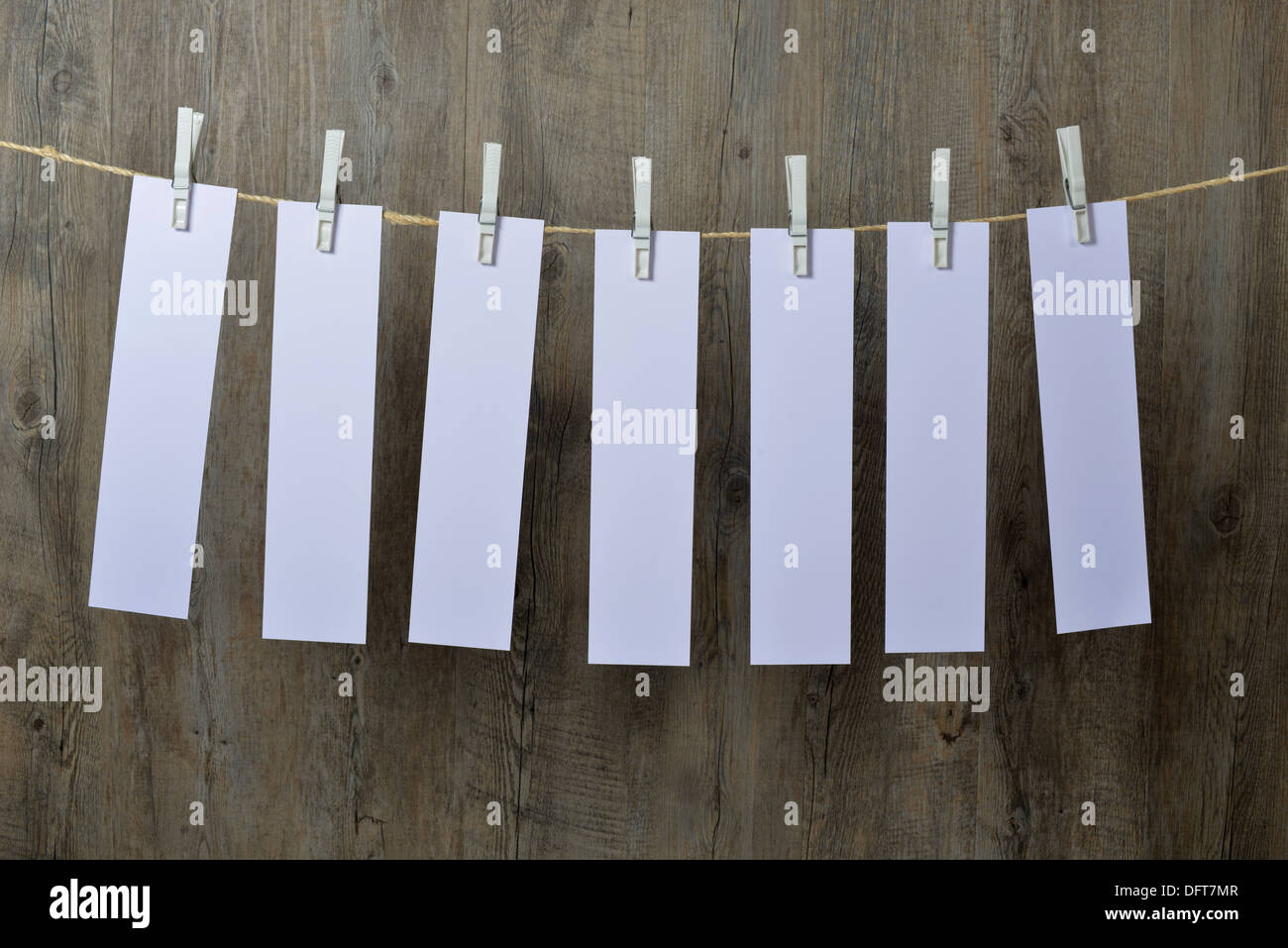 seven sheets of paper hanging on a clothesline Stock Photo - Alamy