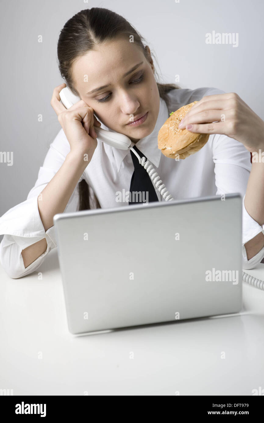 Business Woman on Phone Eating Sandwich and Working Stock Photo - Alamy