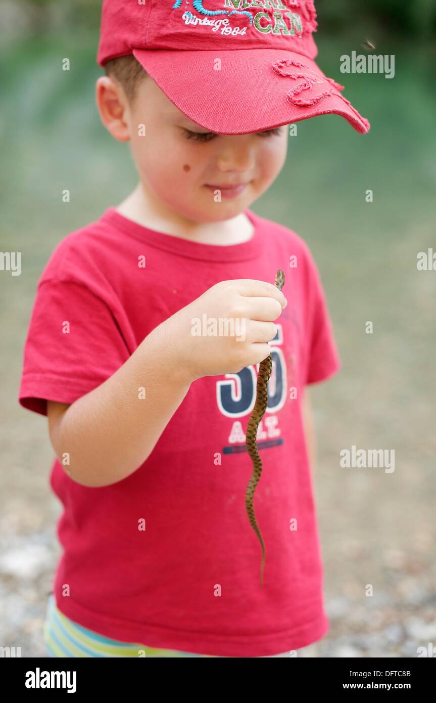 Boy holding a snake hi-res stock photography and images - Alamy