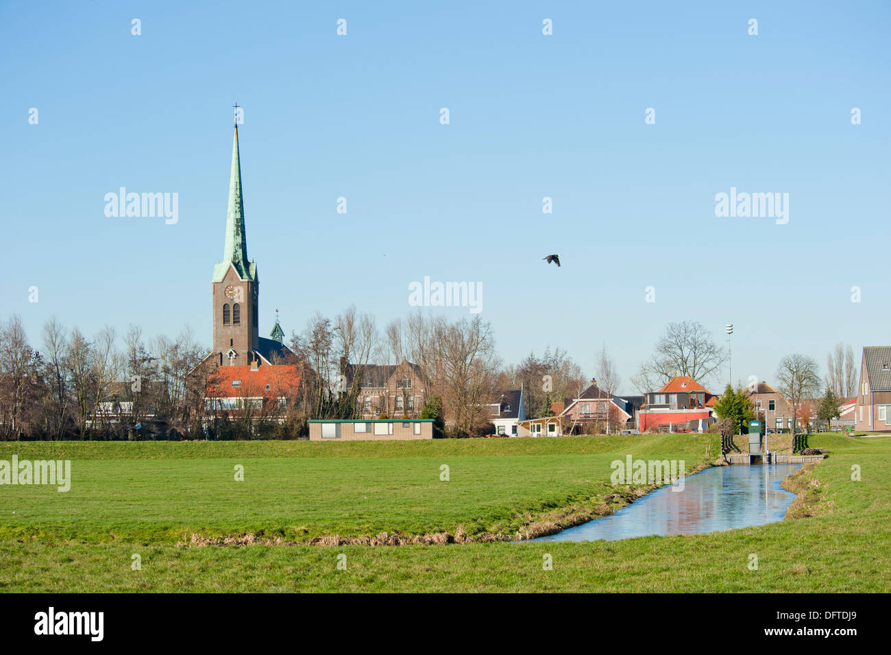 Traditional Dutch small town scenery behind an water embarkment at ...