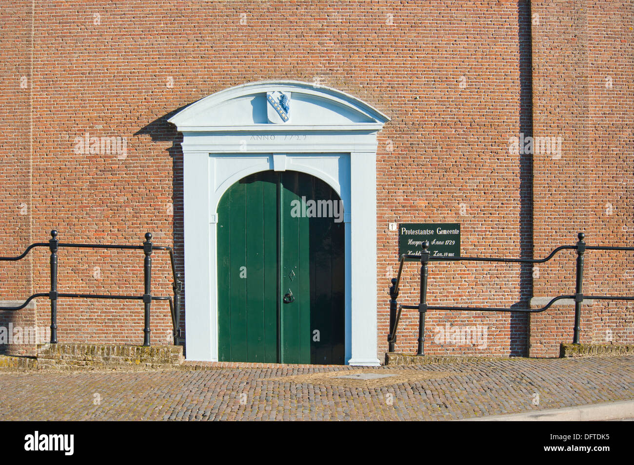 Green entrance door with decorative white arch shaped wall recess of ...