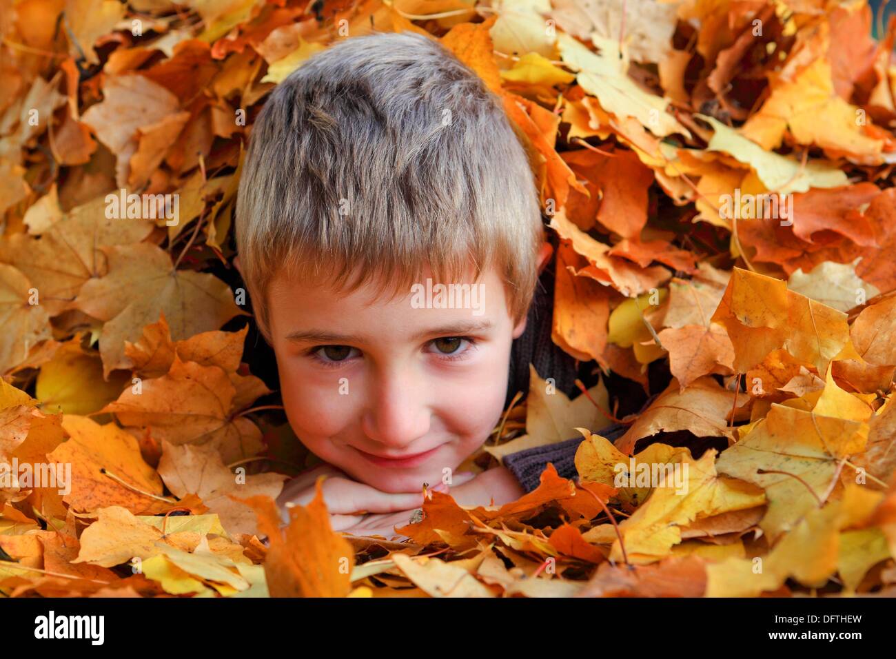 Child buried in leaves in leaves hi-res stock photography and images ...