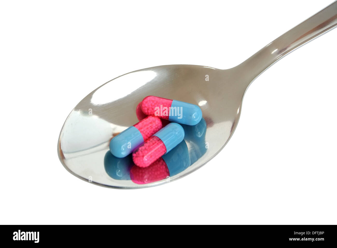 Capsules in the spoon to be taken Stock Photo - Alamy