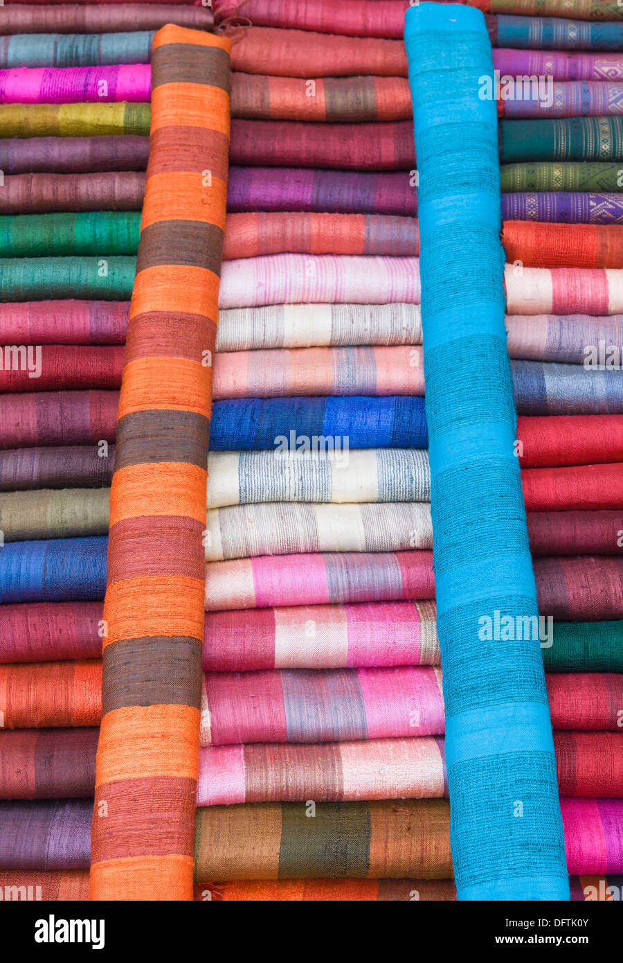 Colourful silk textiles on display at a market stall in Luang Prabang ...