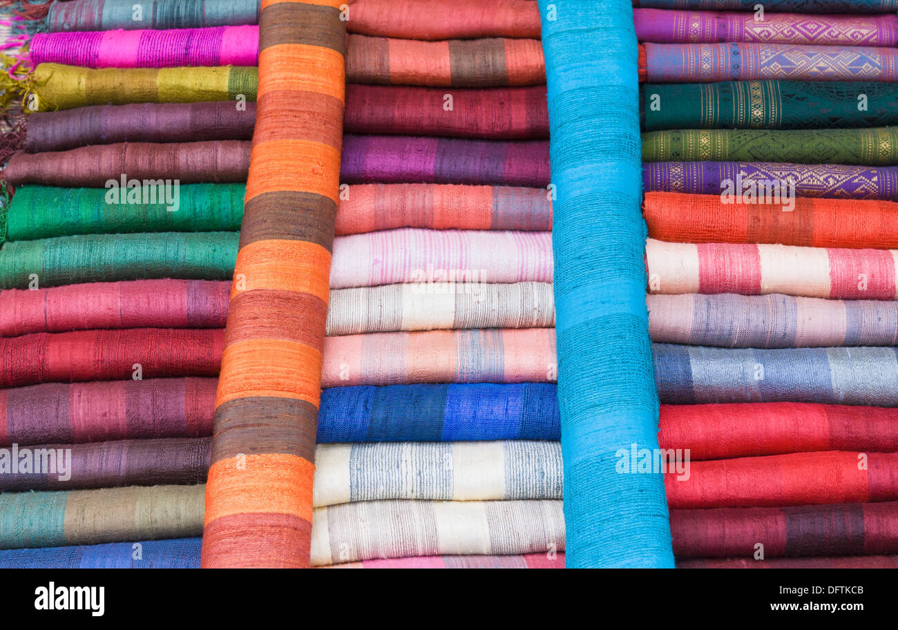 Colourful silk textiles on display at a market stall in Luang Prabang ...