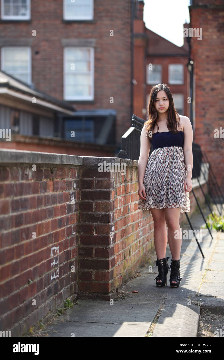 Urban girl standing next to wall Stock Photo - Alamy