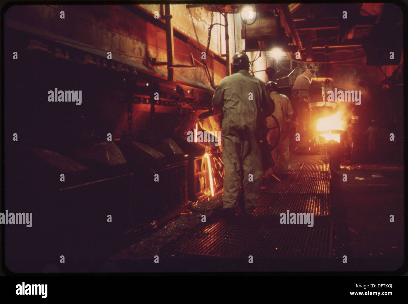 Workers are shown pouring sand castings at the Ford Foundry in Dearborn ...
