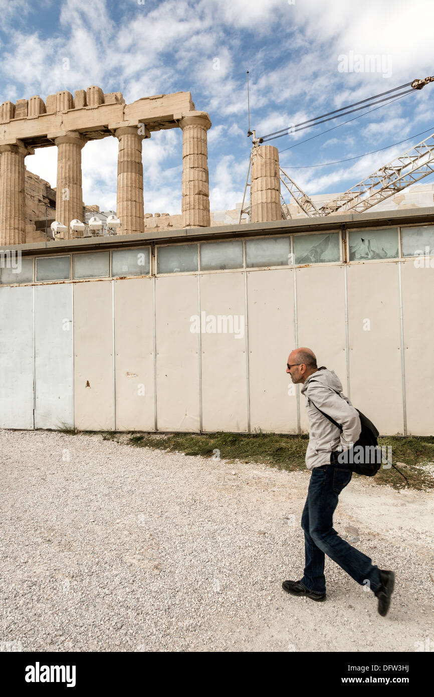 A man walks in front of the ancient Temple of Parthenon atop the ...
