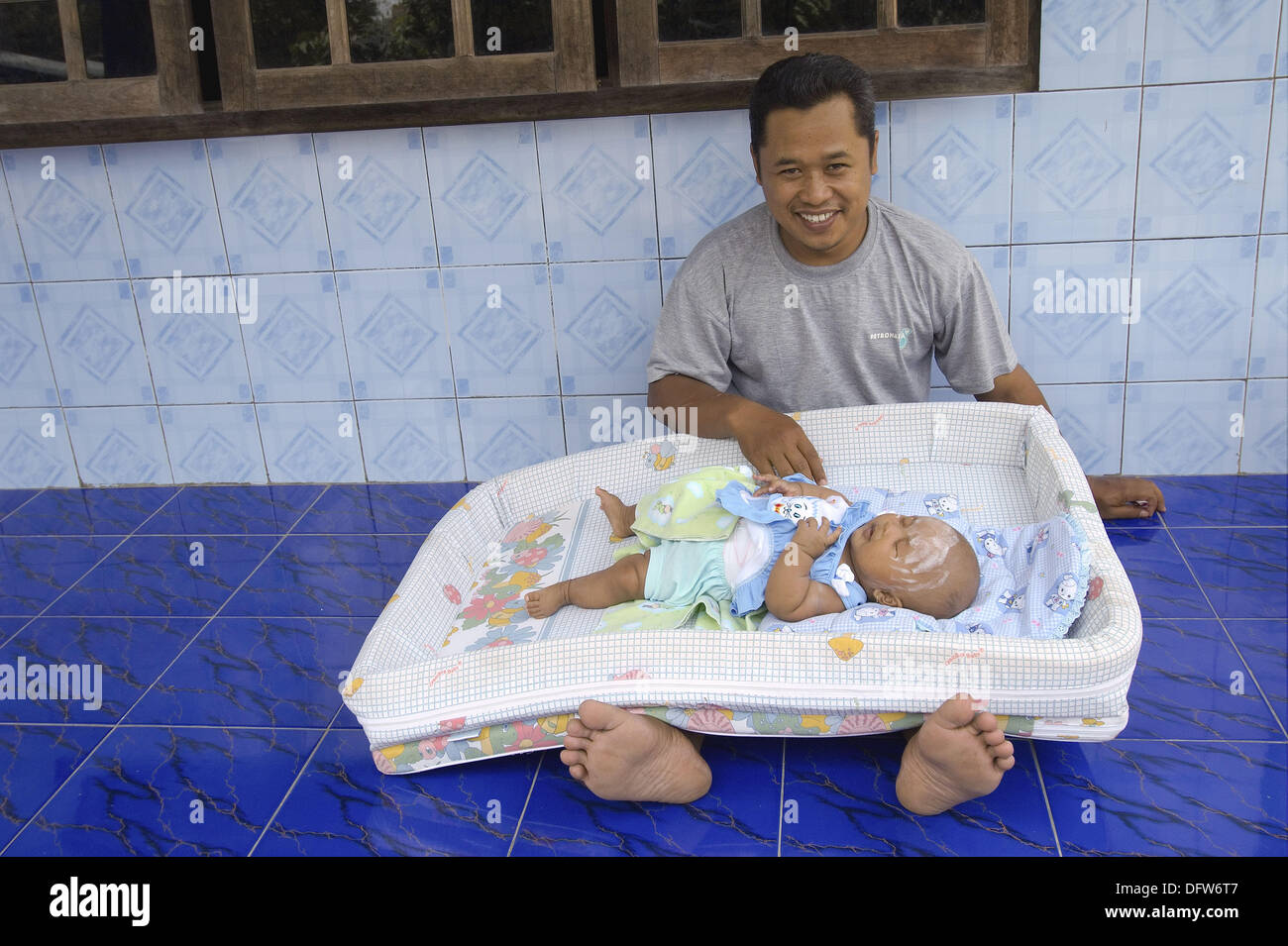 a man with his baby smile and look in camera. borobudur village ...