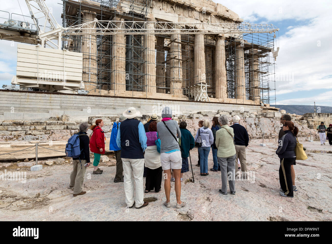Tourists stand in front of the ancient Temple of Parthenon atop the ...