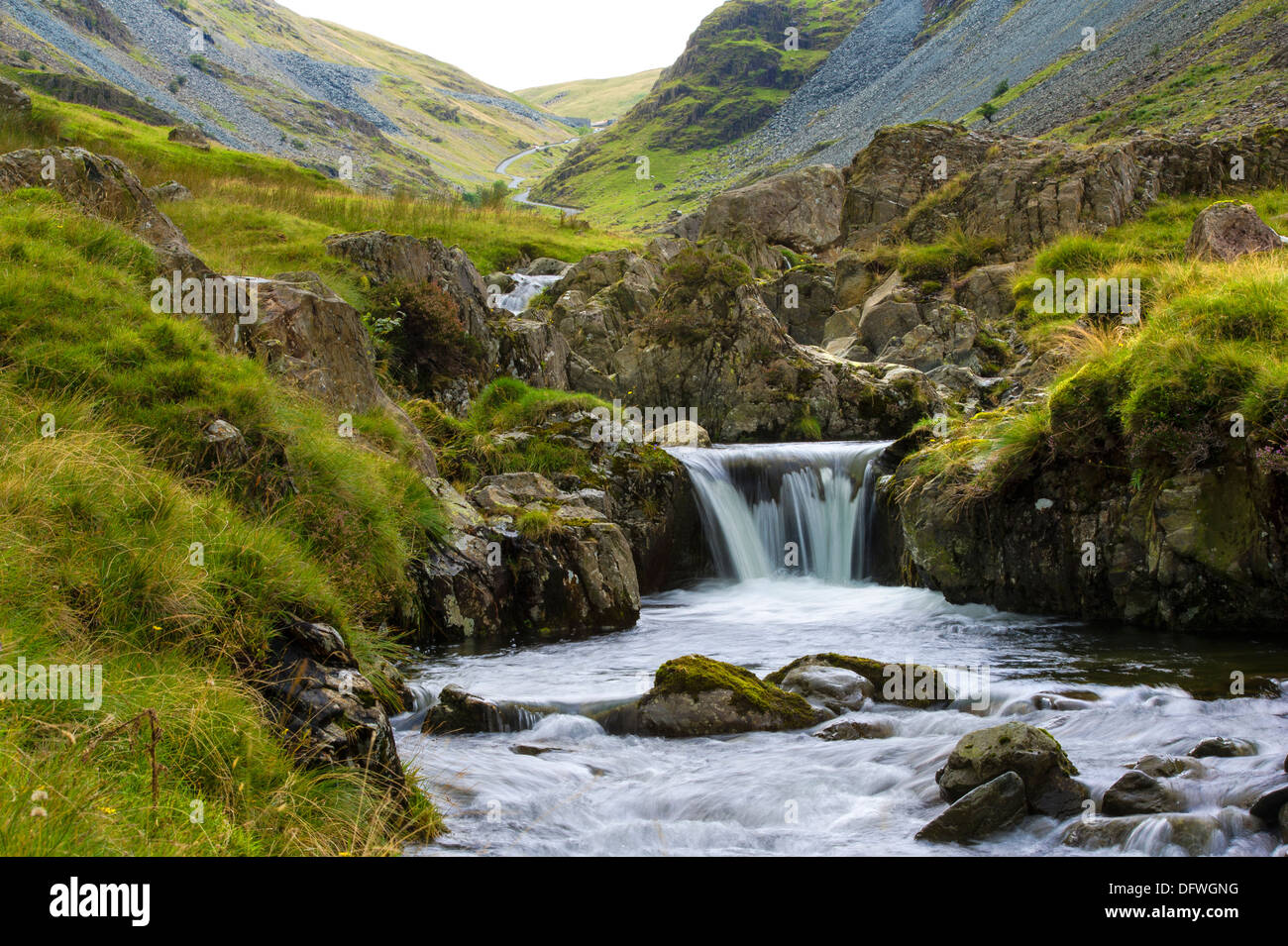A small waterfall running alongside the road, near the bottom of the ...