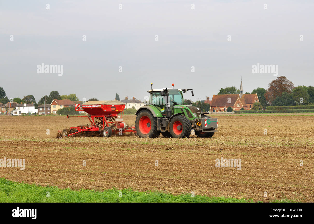 Tractor Tilling and fertilising a field in England Stock Photo - Alamy