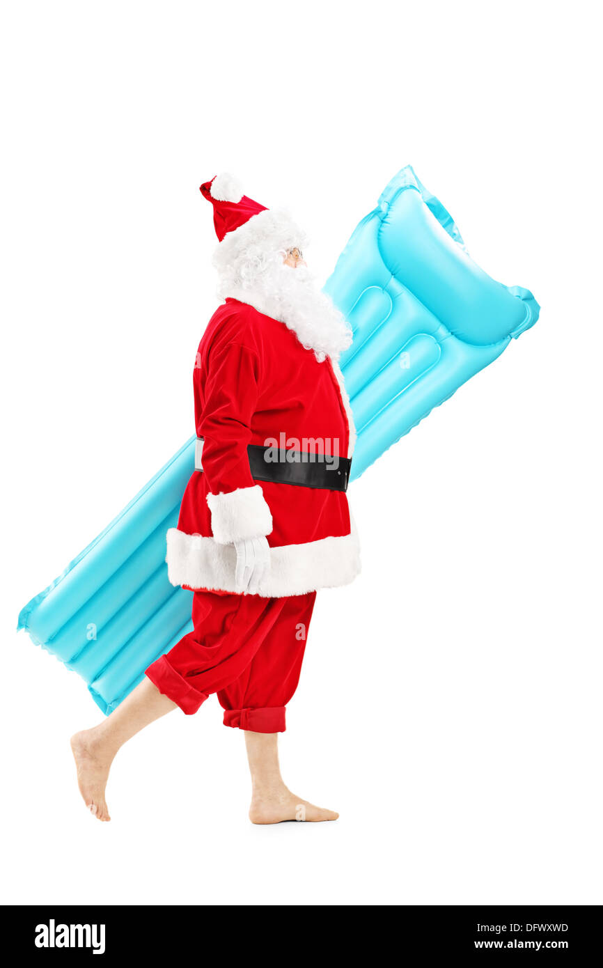 Full length portrait of a Santa claus walking with a swimming mattress ...