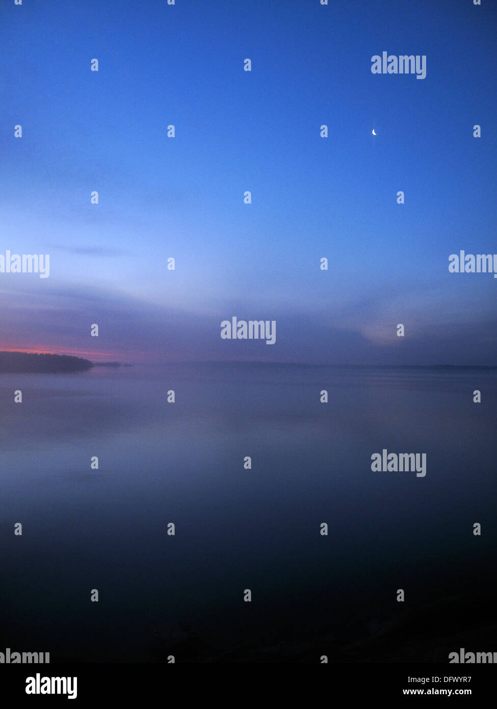 Crescent Moon Over Misty Lake at Sunset Stock Photo - Alamy
