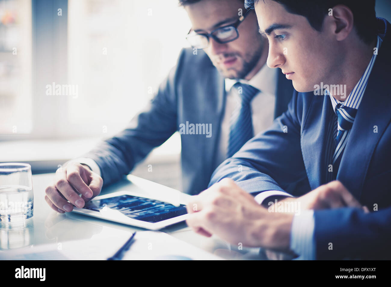 Image of two young businessmen using touchpad Stock Photo - Alamy