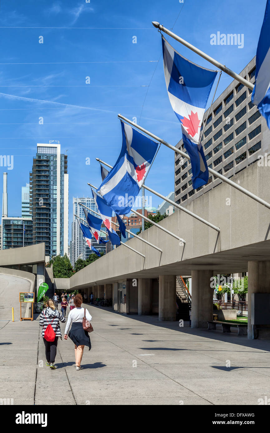 People walk past blue, white and red flags with maple leaf In Nathan ...