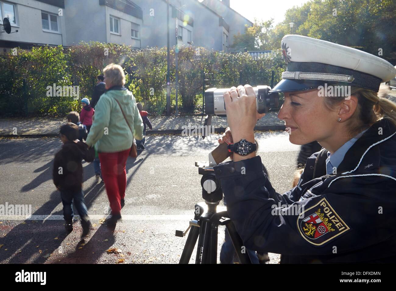 A police checks the speed of a passing car with a laser speed detector ...