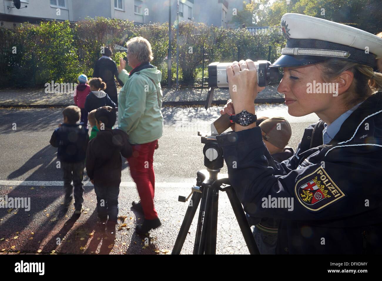 A police checks the speed of a passing car with a laser speed detector ...