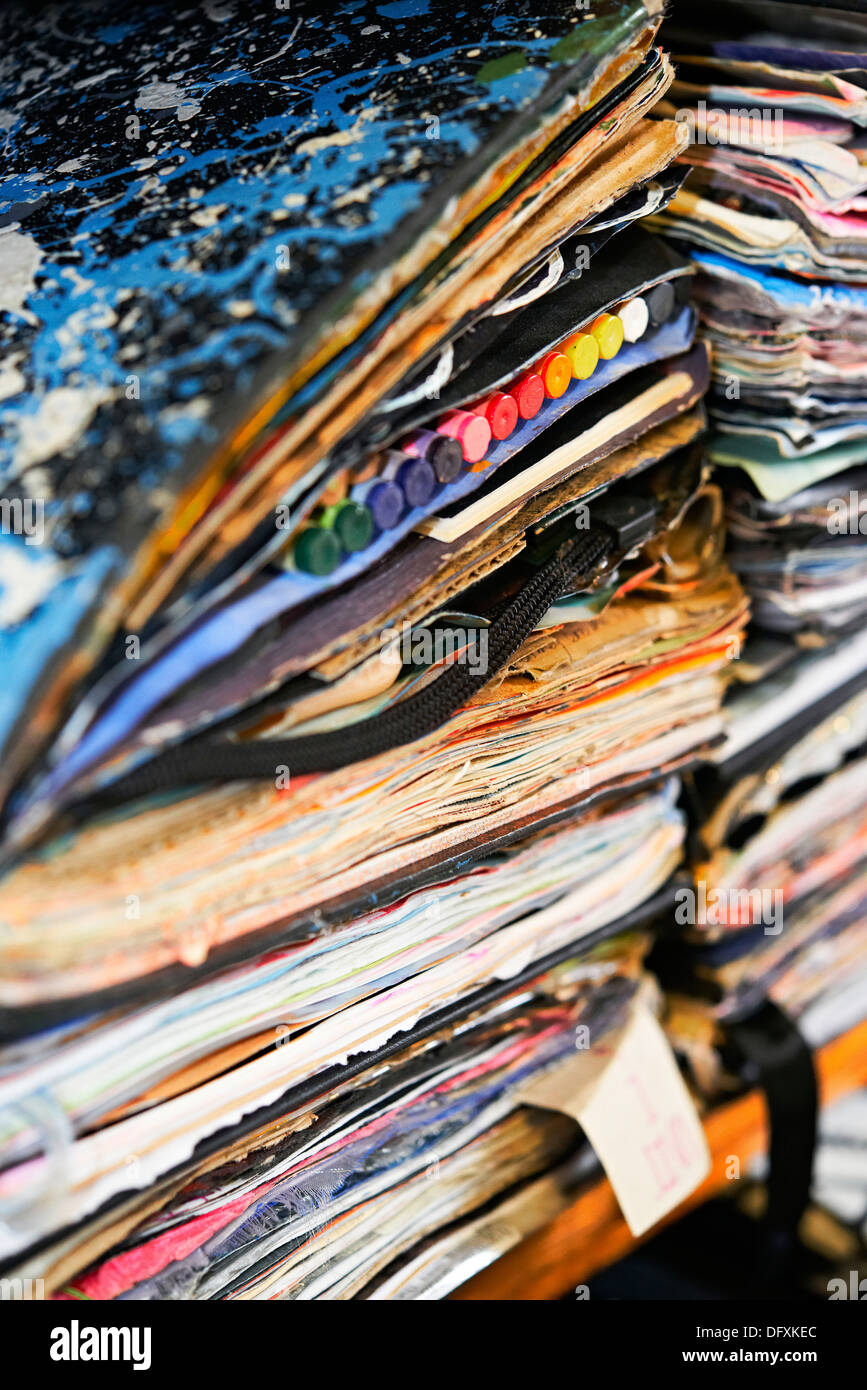 A pile of scrap books, decorated art sketch pads,with text and color ...