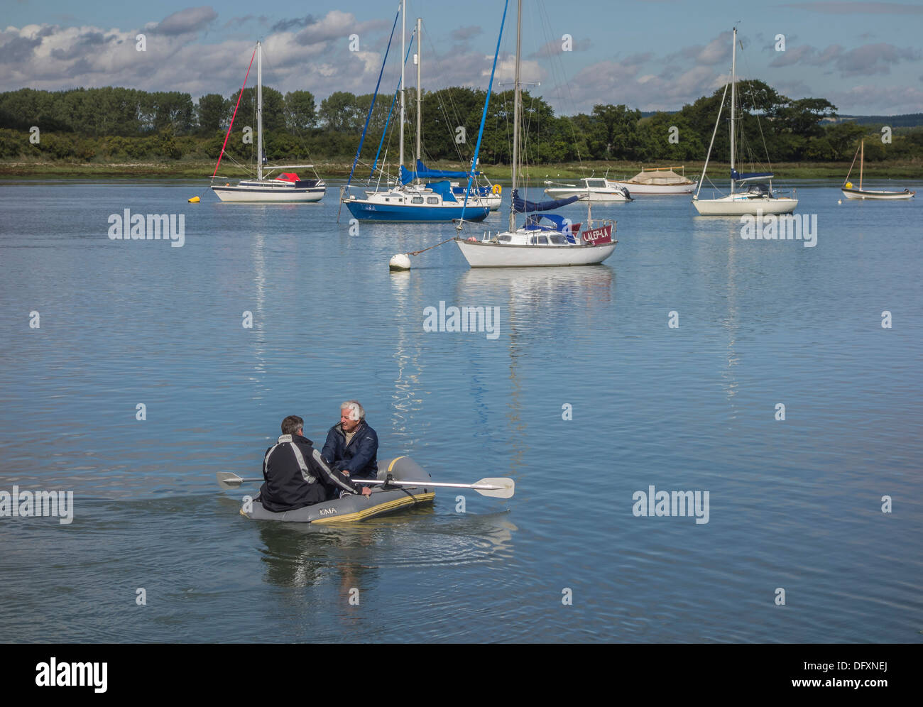 Chichester Harbour, Two men in a dinghy rowing from Dell Quay, West ...