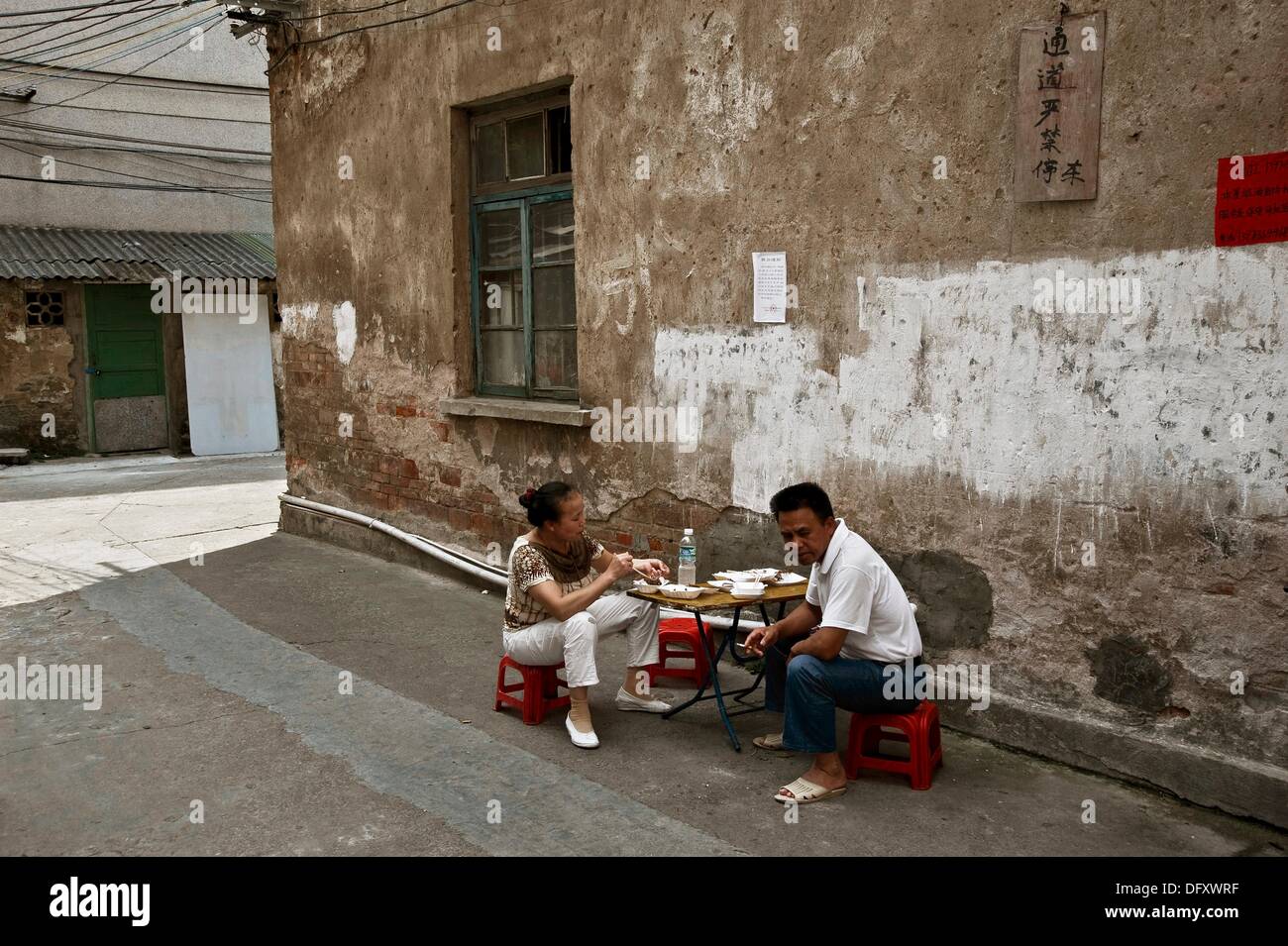 Couple eating at a table in the street. Guilin, China Stock Photo - Alamy