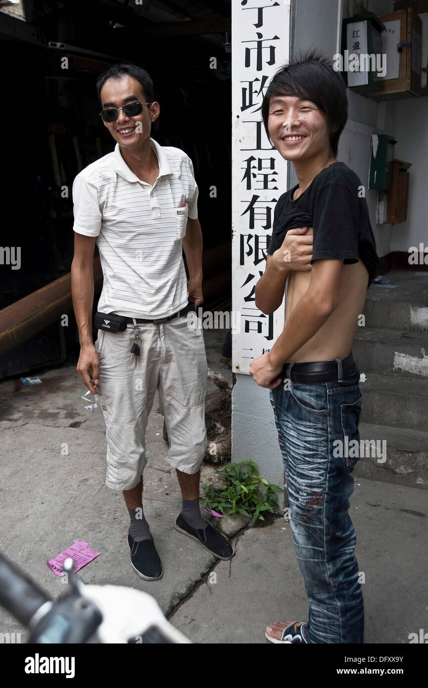 Two men laugh at the gates of his work. Shanghai, China Stock Photo - Alamy