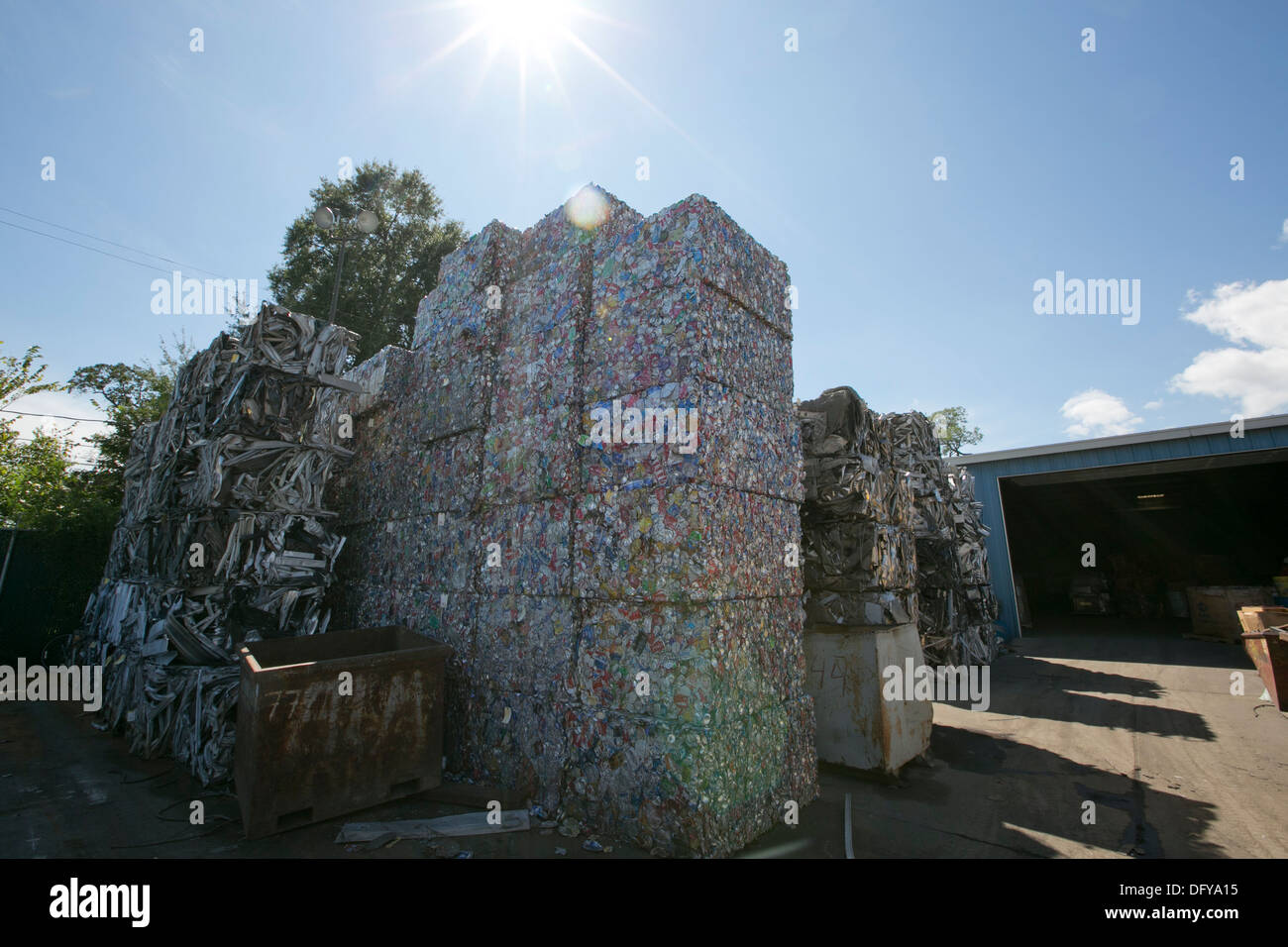 crushed and compacted cubes of metal and aluminum cans at a scrap metal ...