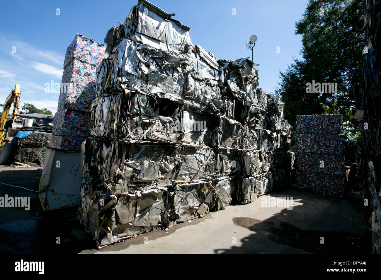 crushed and compacted cubes of metal and aluminum cans at a scrap metal ...