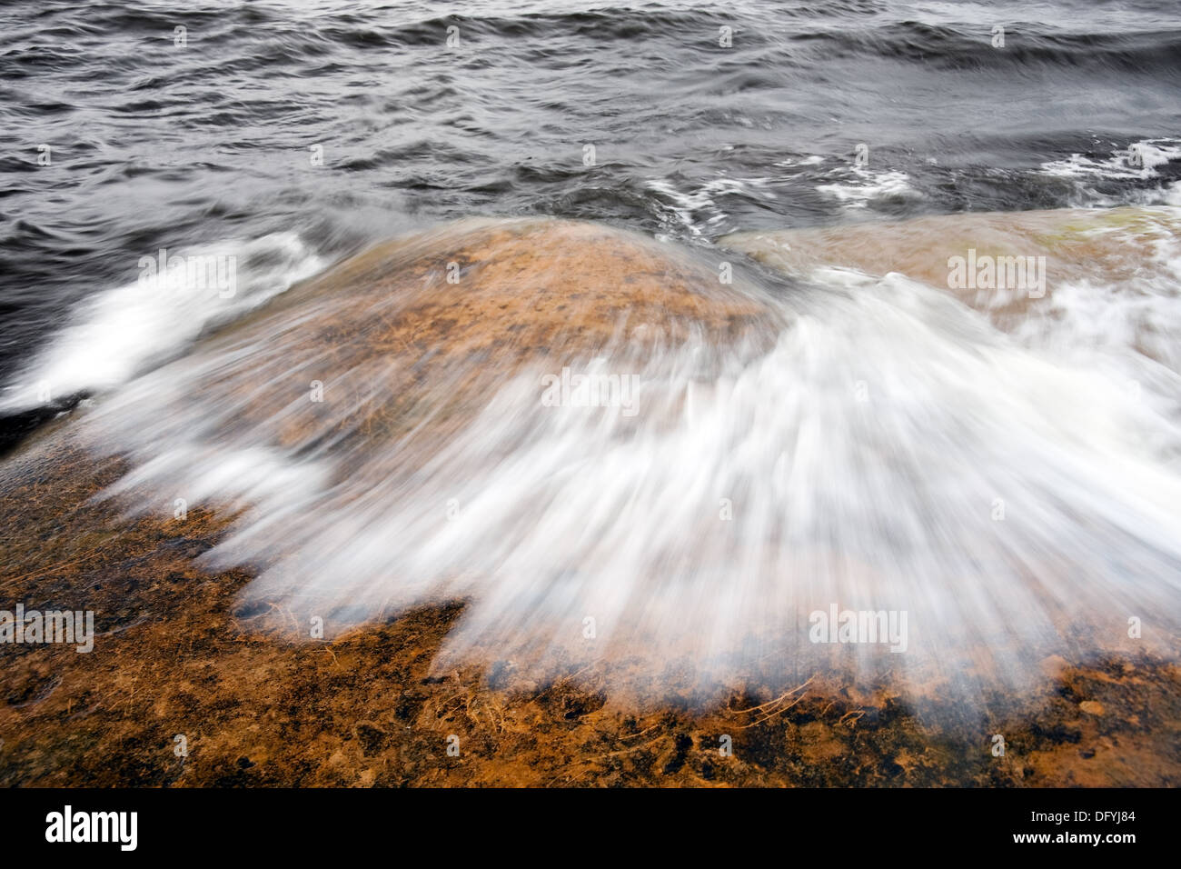 Wave hat on rock Stock Photo - Alamy