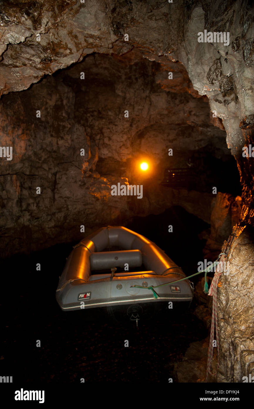 Inflatable boat in underground cave with rock formation and light ...