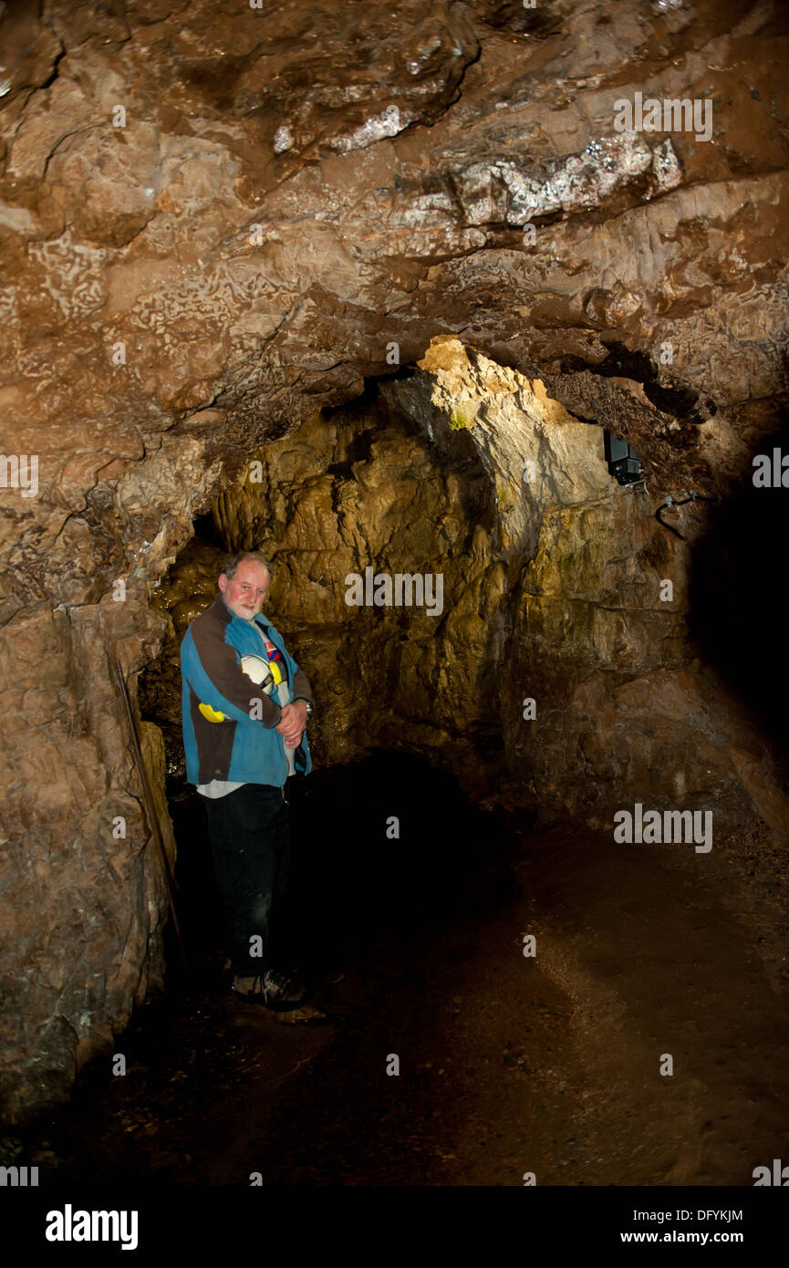 Man standing in rock cave below ground Stock Photo - Alamy