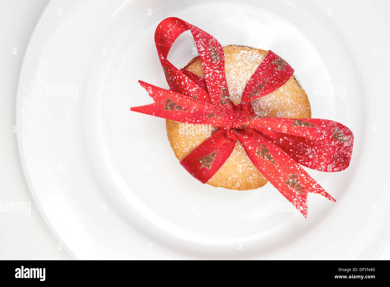Sweet Christmas mince pie with a red ribbon tied round it on a White ...