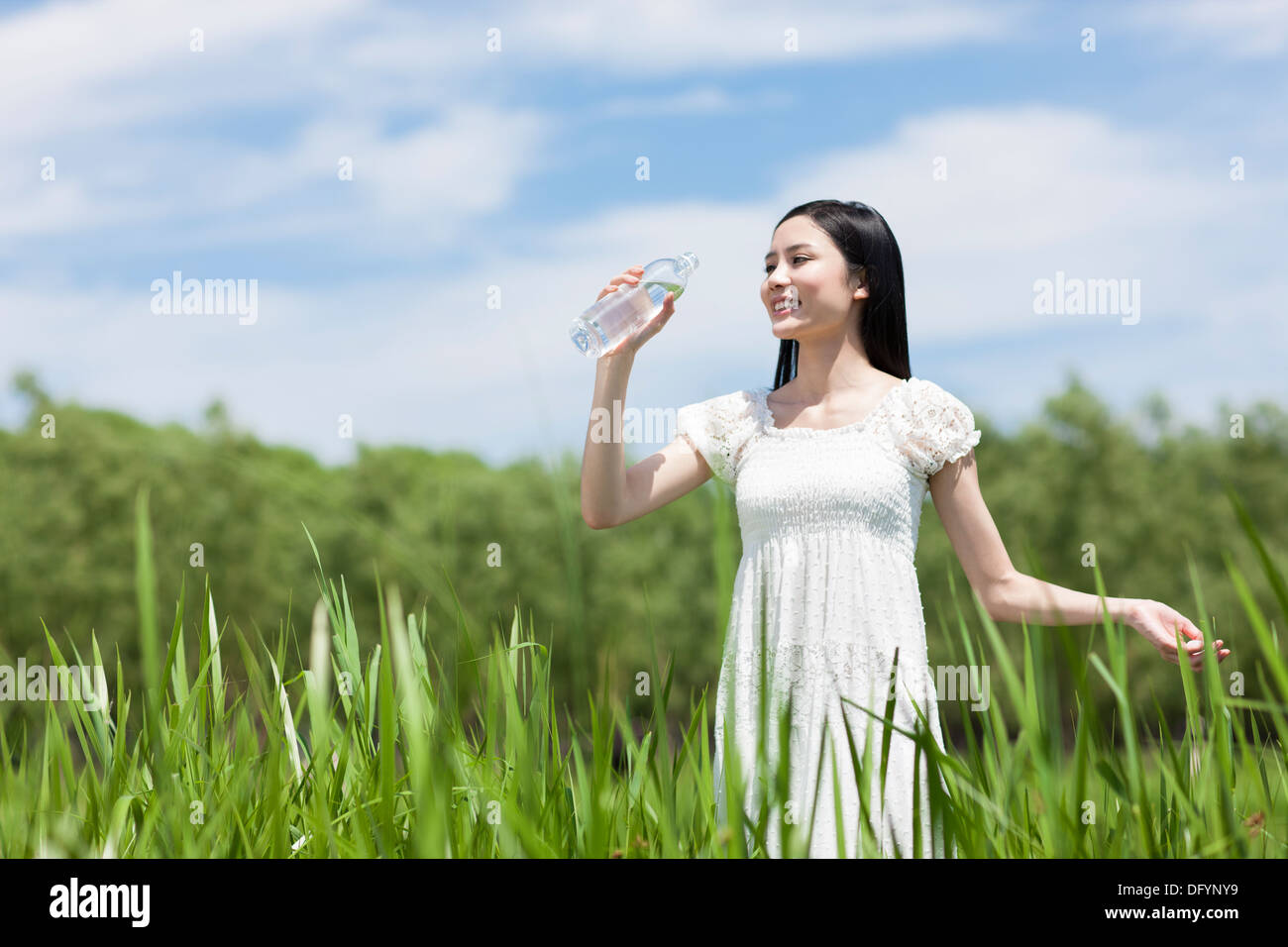 Young woman drinking water outdoors Stock Photo - Alamy