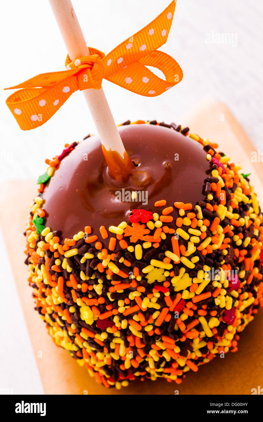 Hand dipped caramel apple covered with multi color sprinkles Stock ...