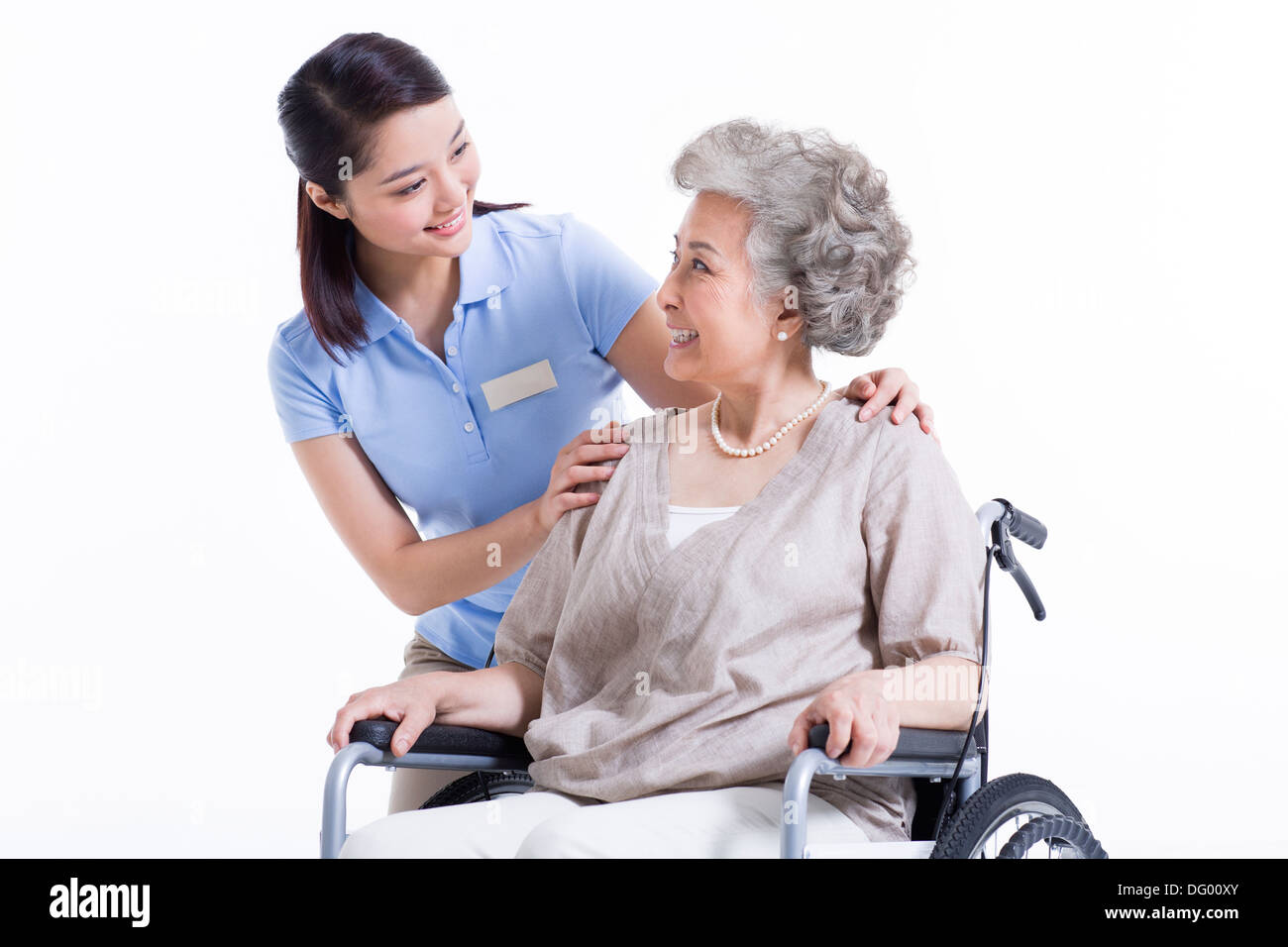 Female nursing assistant taking care of senior in wheelchair Stock ...