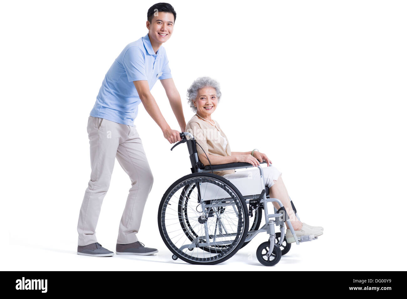 Male nursing assistant taking care of senior in wheelchair Stock Photo ...