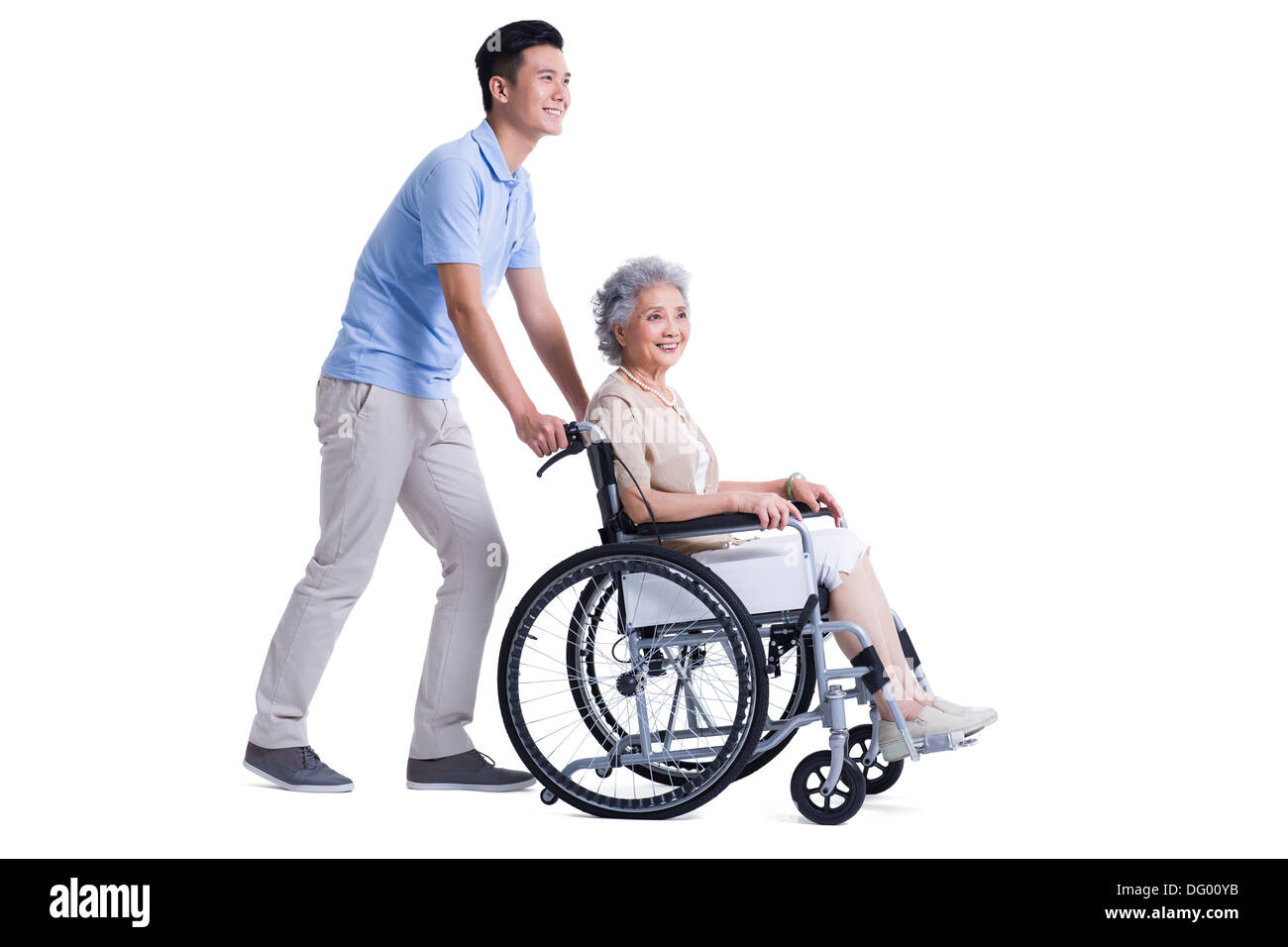 Male nursing assistant taking care of senior in wheelchair Stock Photo ...