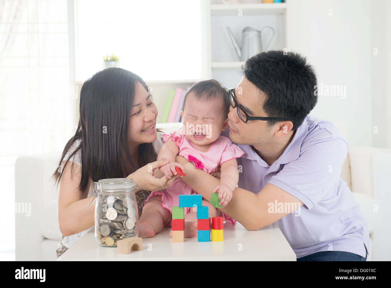 crying asian baby being comforted by chinese parents Stock Photo - Alamy