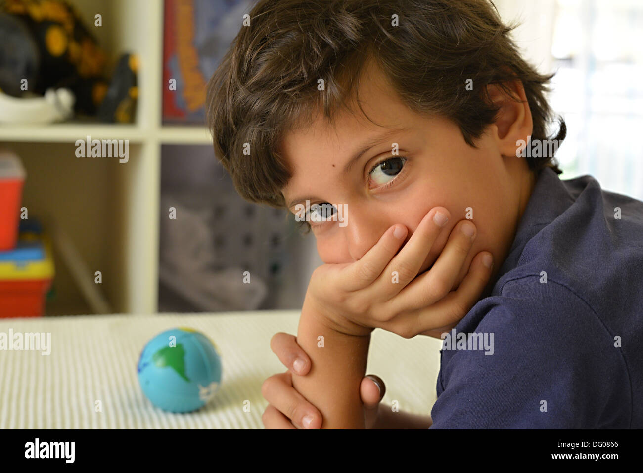 Boy making plans for the future with Earth miniature near him Stock ...