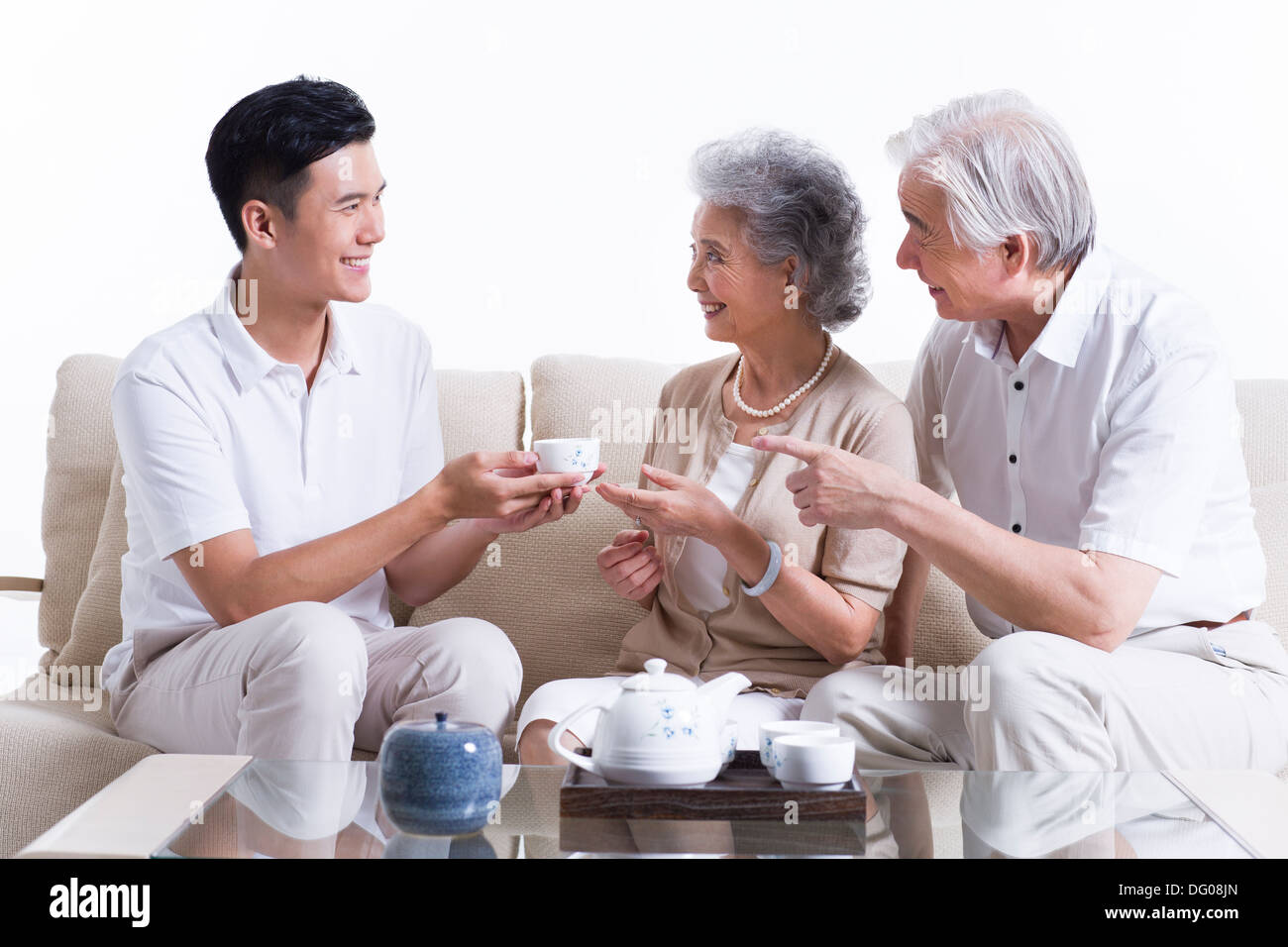 Happy family having tea and chatting Stock Photo - Alamy